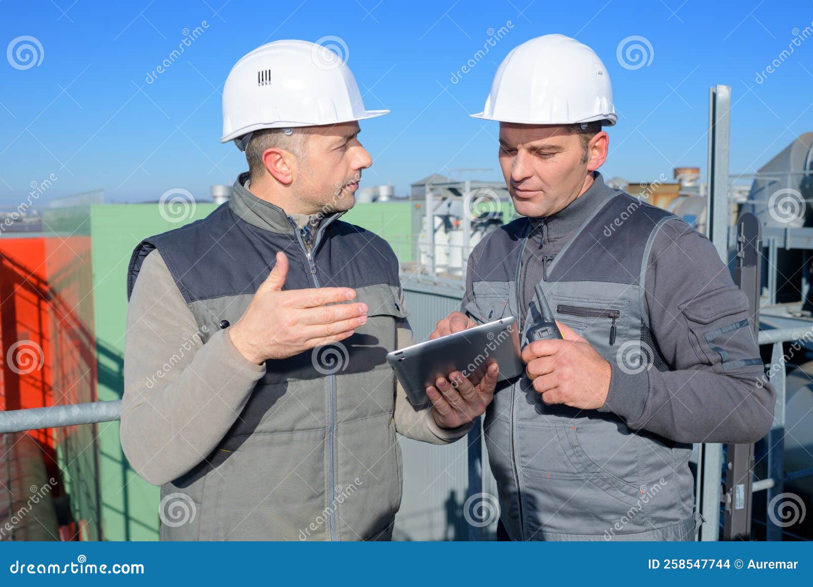 Two Men Looking at Tablet Stood Overlooking Industrial Factory Stock ...