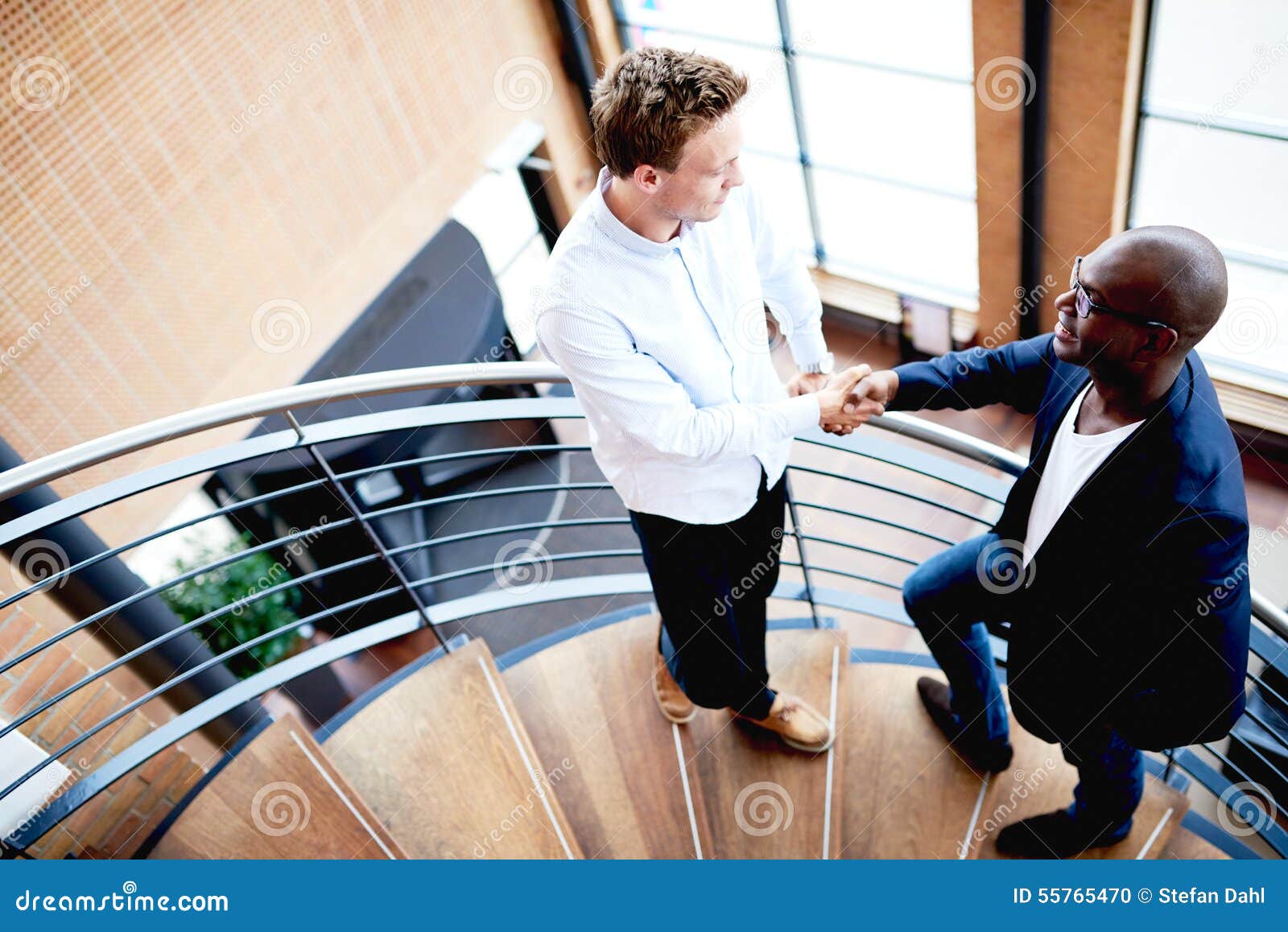 Two Men in Modern Office Building Shaking Hands and Smiling Stock Photo ...
