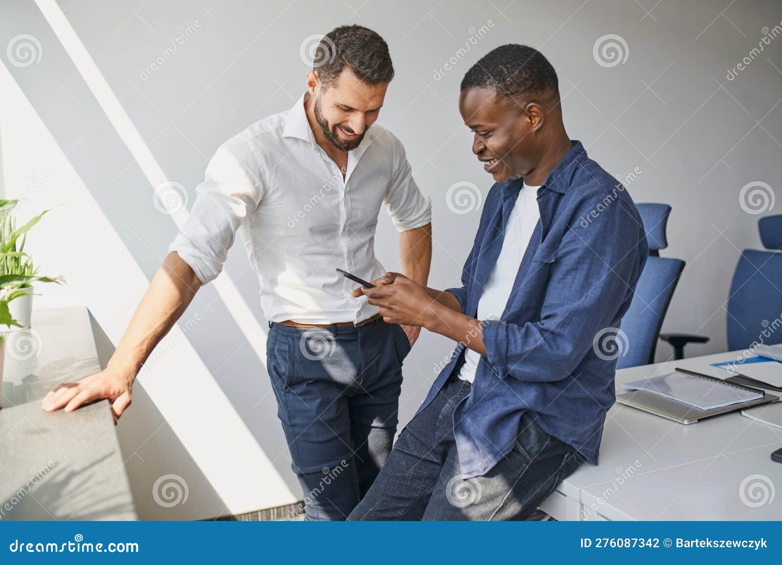 Two Businessmen at Office Having Fun Sharing Something on the Phone ...