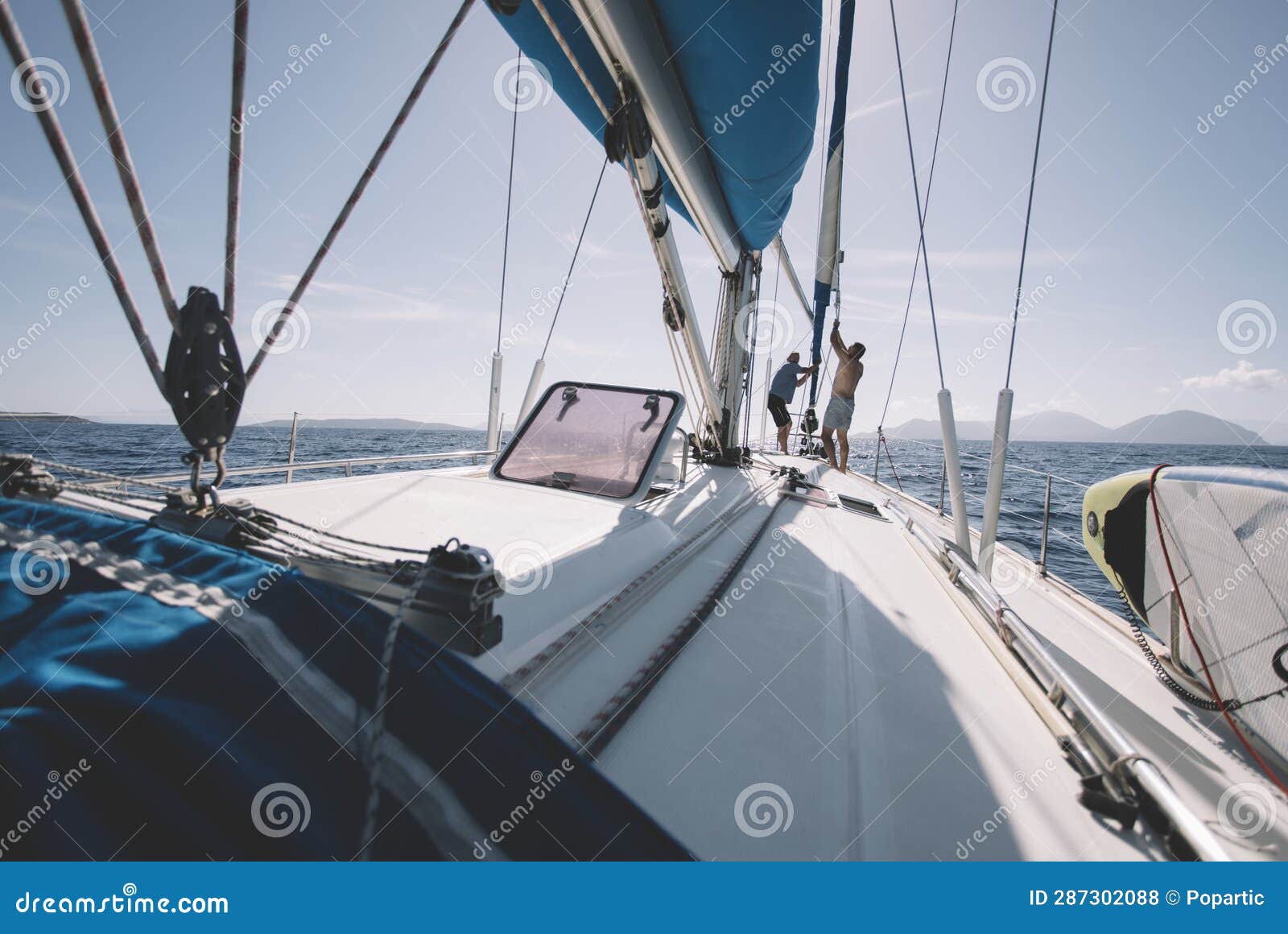 Two Men Pulling the Rope, Setting Up Sails on Sailboat Stock Photo ...
