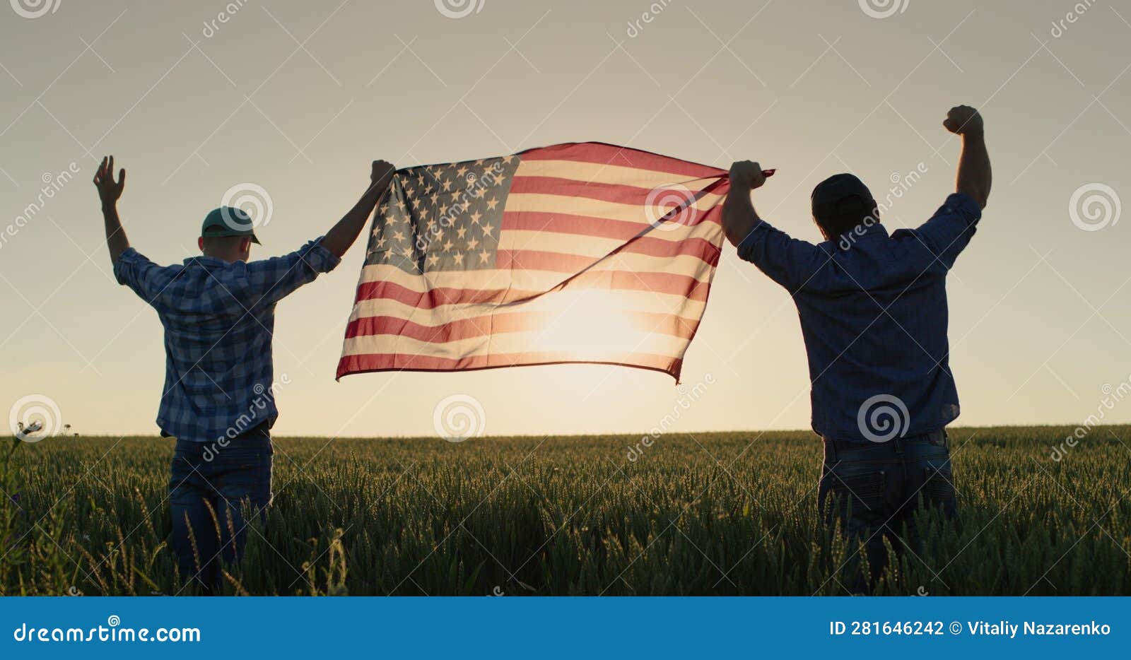 Two Men Raise Up the US Flag Against the Backdrop of a Wheat Field at ...