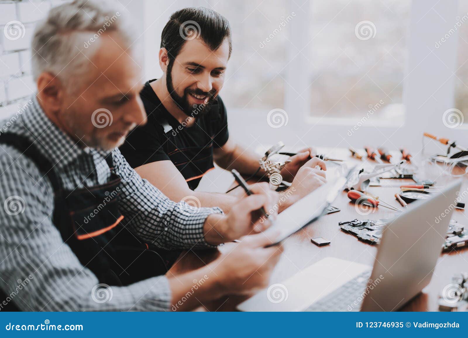 Two Men Repairing Hardware Equipment in Workshop. Stock Image - Image ...