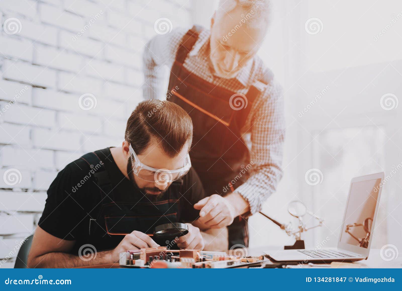Two Men Repairing Hardware Equipment in Workshop. Stock Image - Image ...