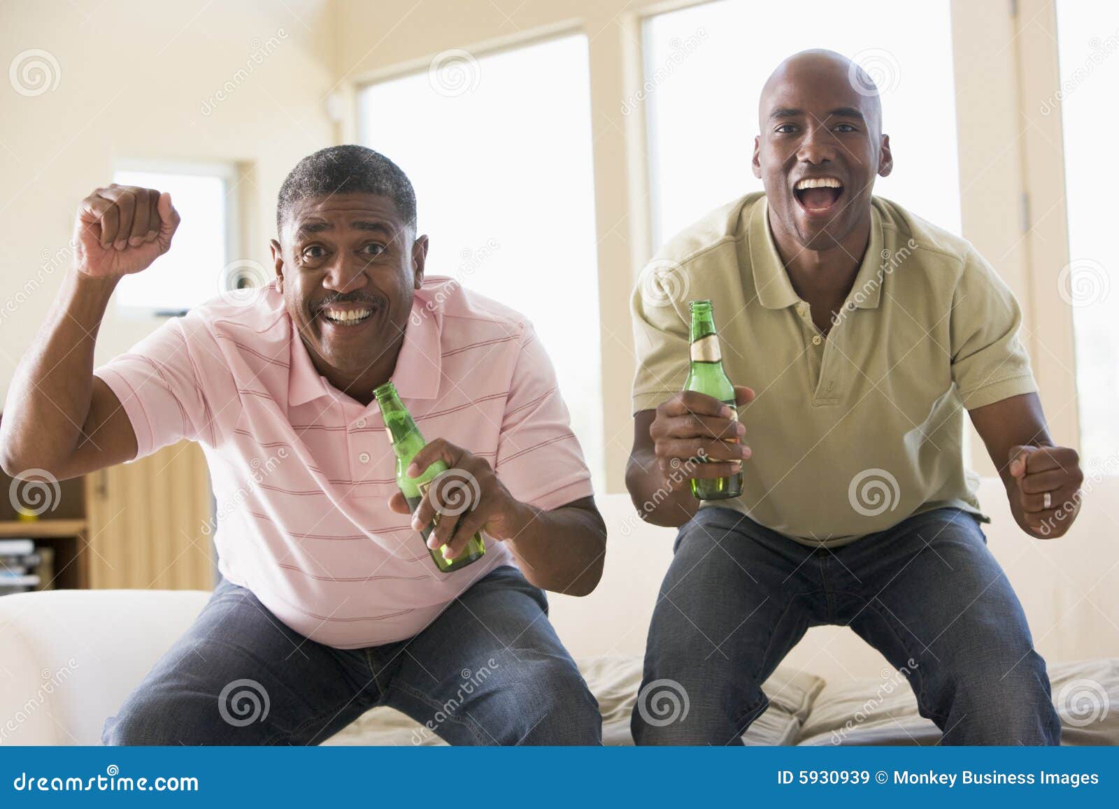 Two Men in Room with Beer Bottles Cheering Stock Image - Image of ...