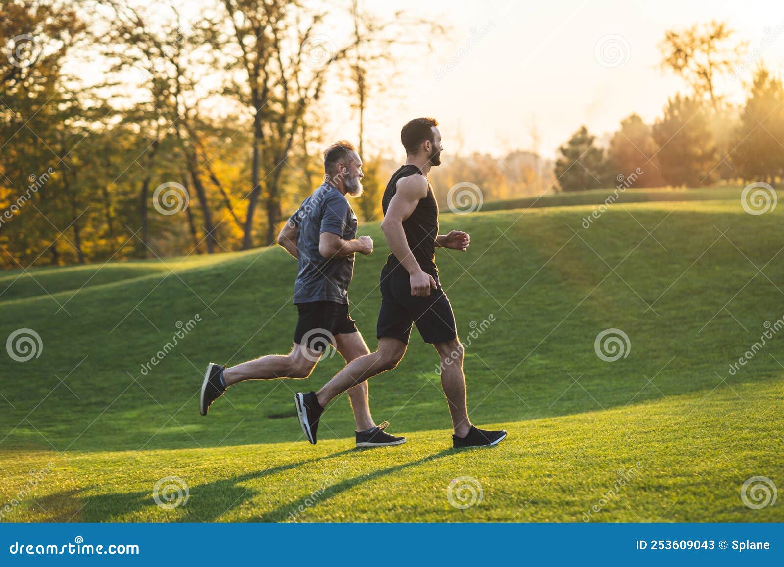 The Two Men Running on the Grass in the Park. Stock Image - Image of ...