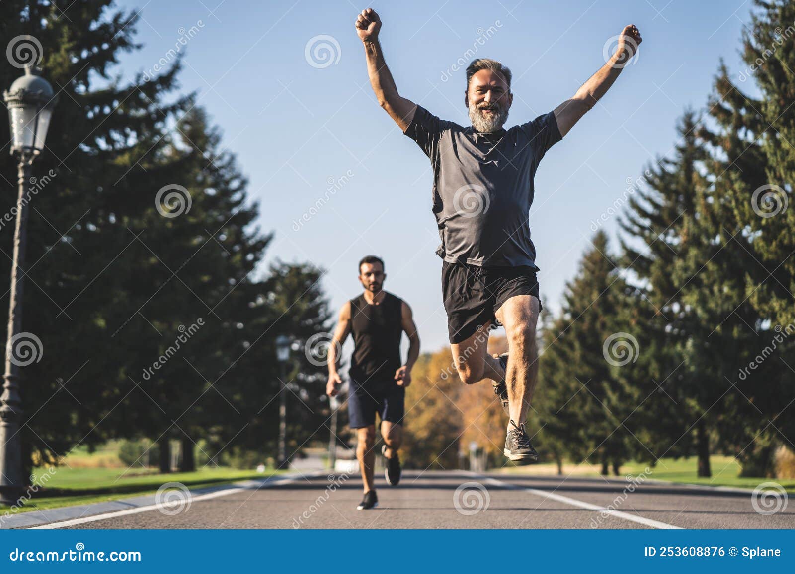 The Two Men Running on the Road in the Park. Stock Photo - Image of ...