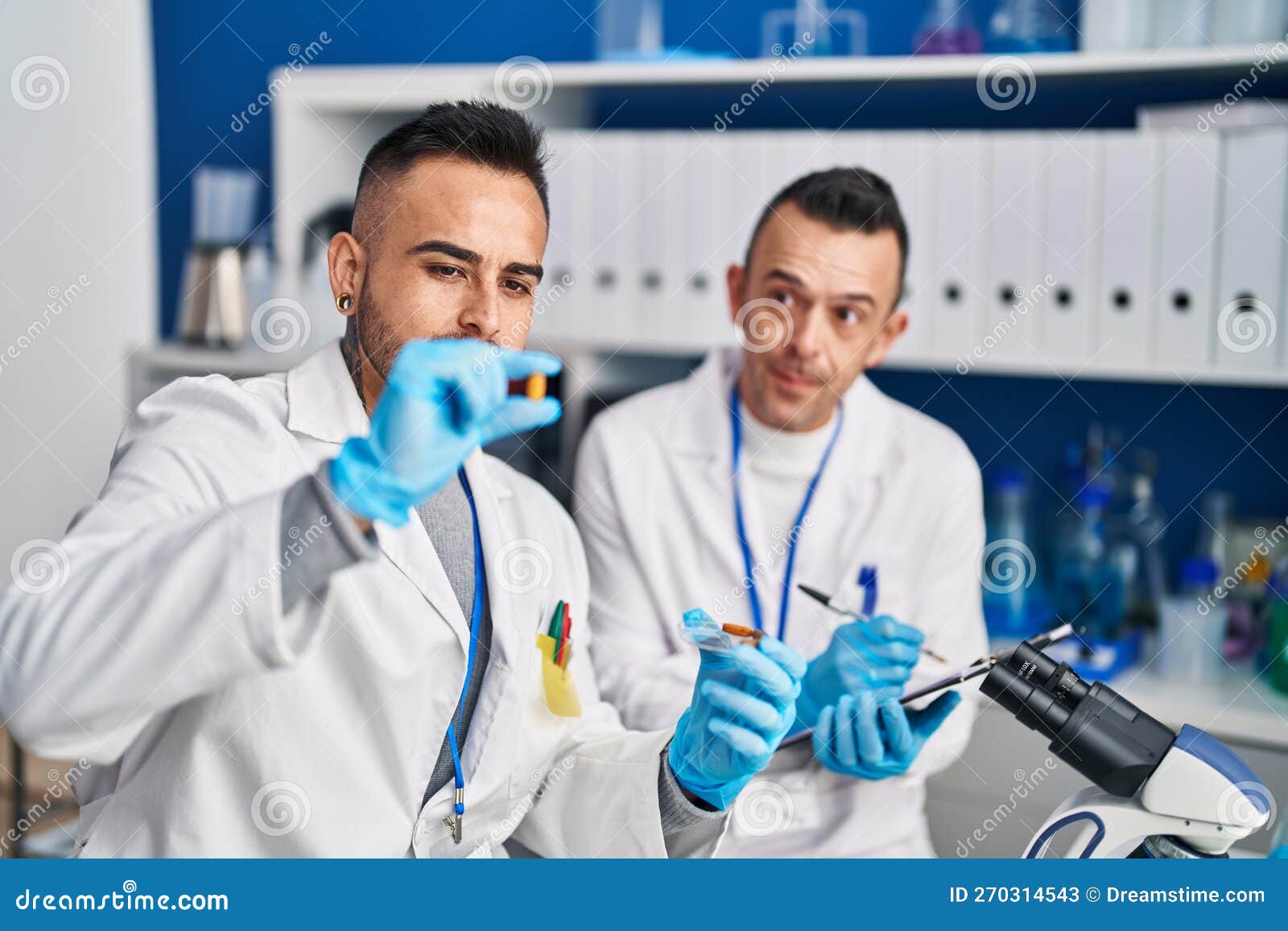Two Men Scientist Writing on Document Holding Pills at Laboratory Stock ...