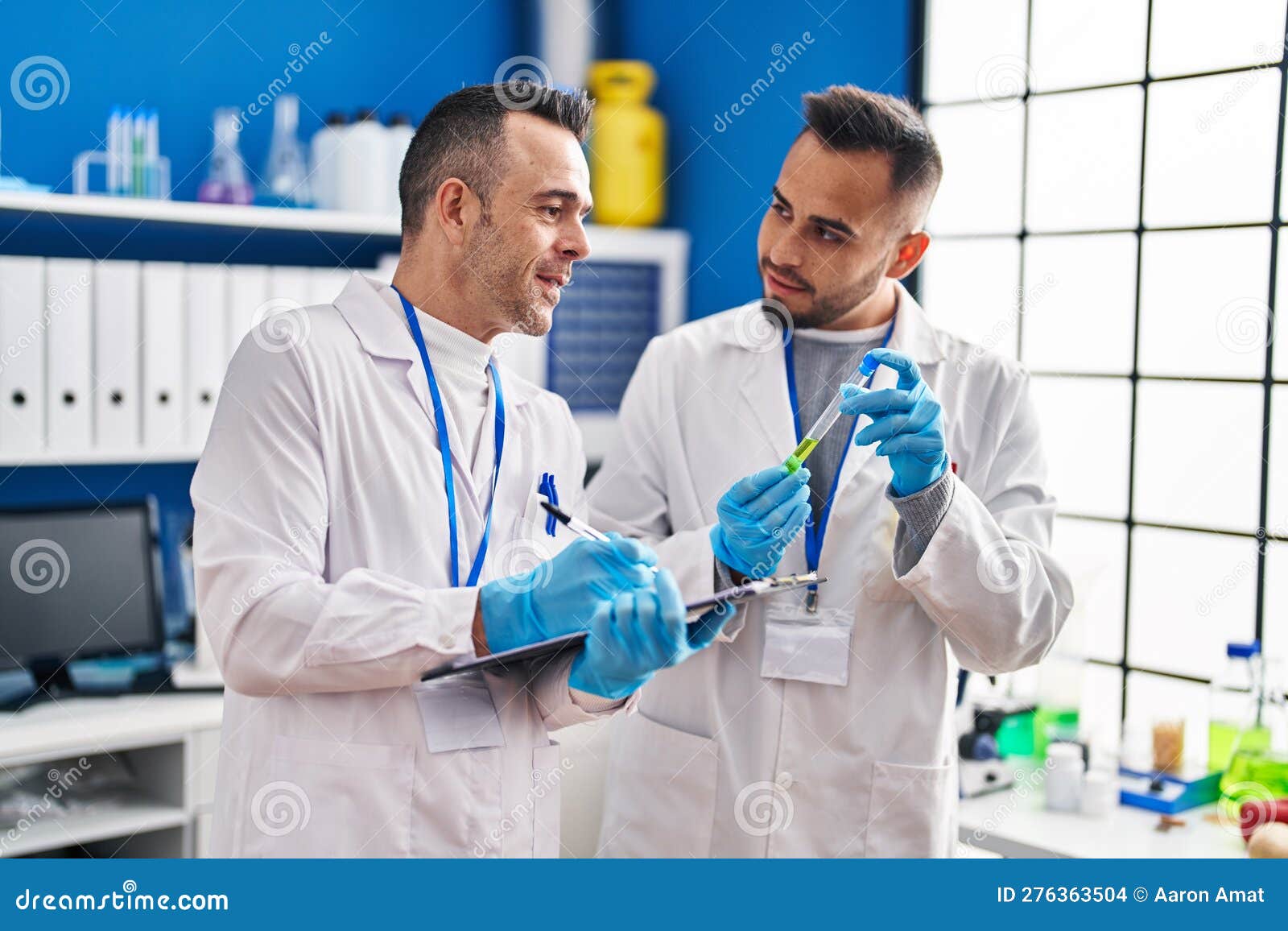 Two Men Scientists Writing on Document Holding Test Tube at Laboratory ...