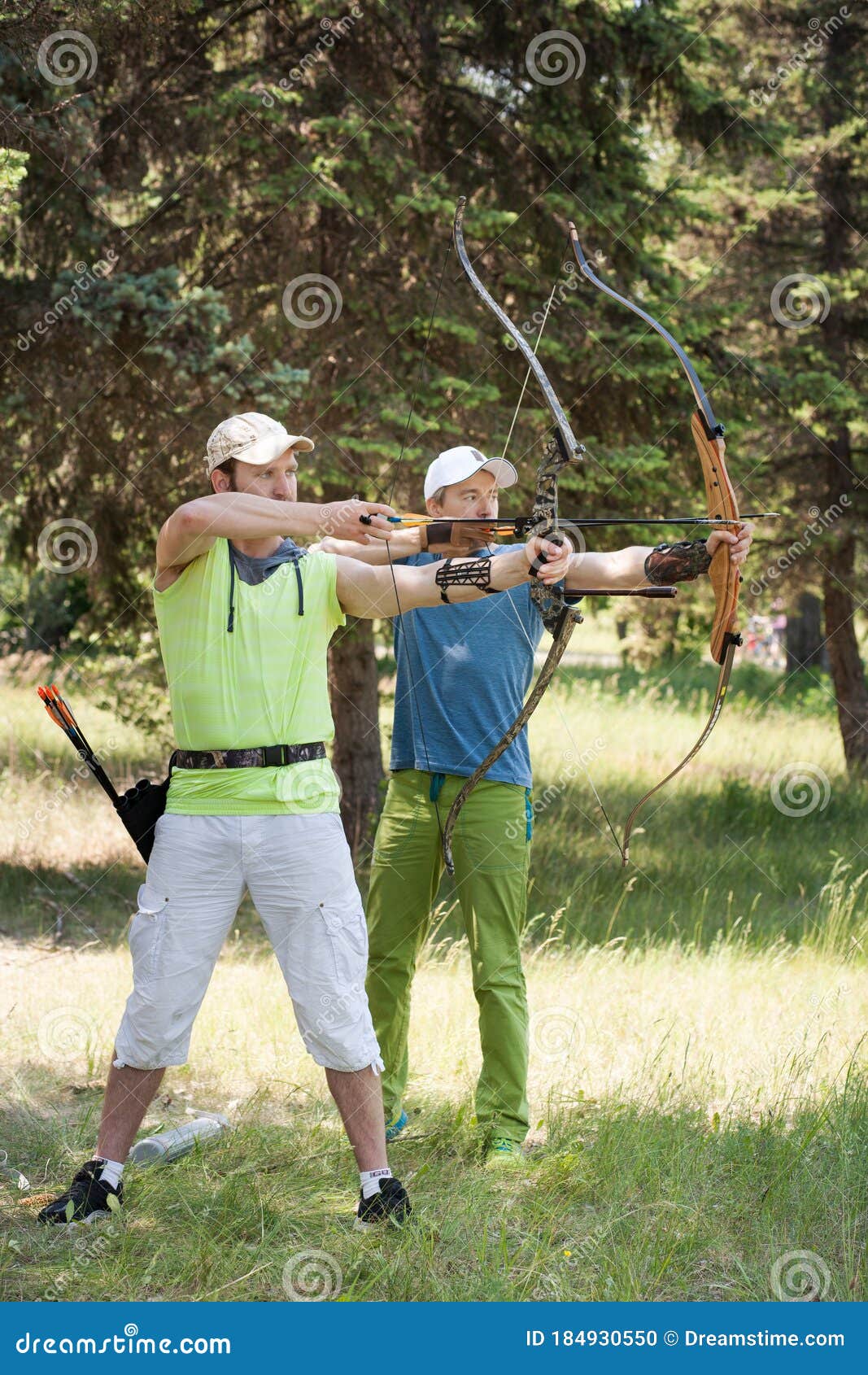 Two Men Shoot from Sporting Bows in the Woods. they are Aiming at the ...
