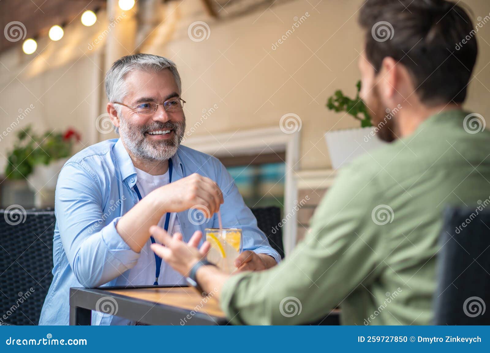 Two Men Sitting in the Cafe and Having an Interesting Conversation ...