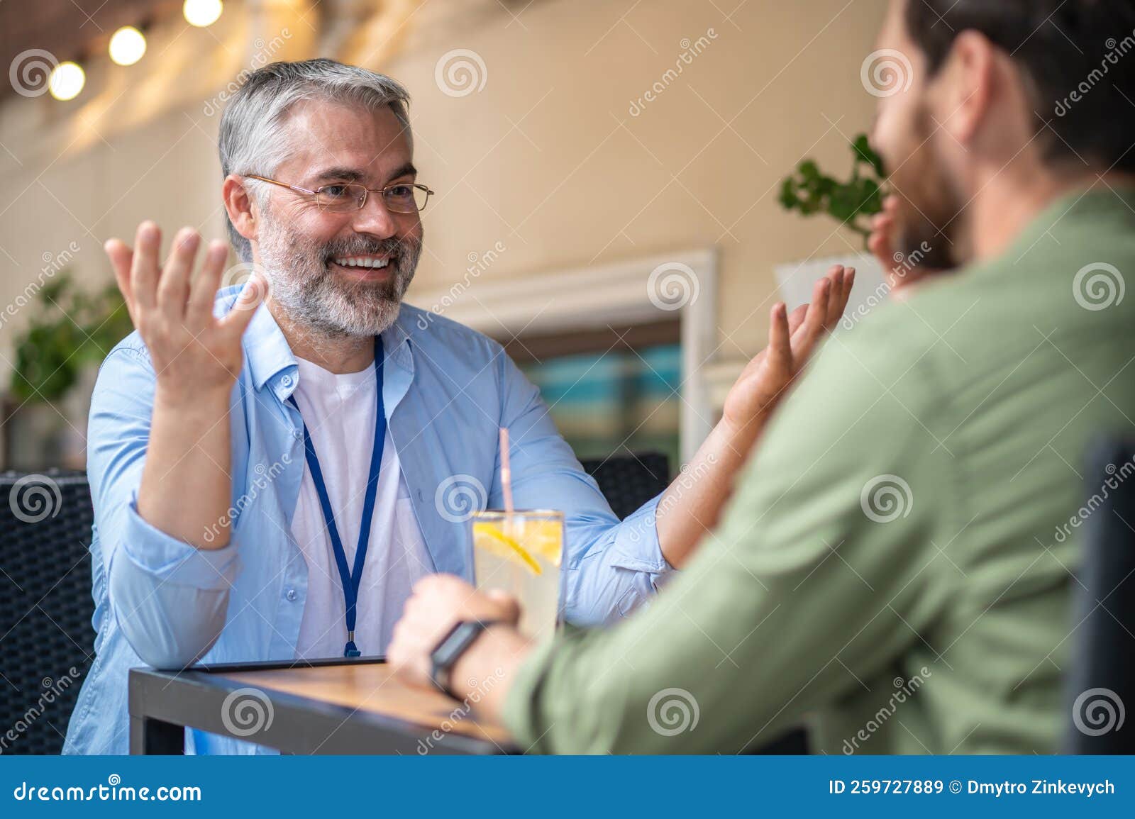 Two Men Sitting in the Cafe and Having an Interesting Conversation ...
