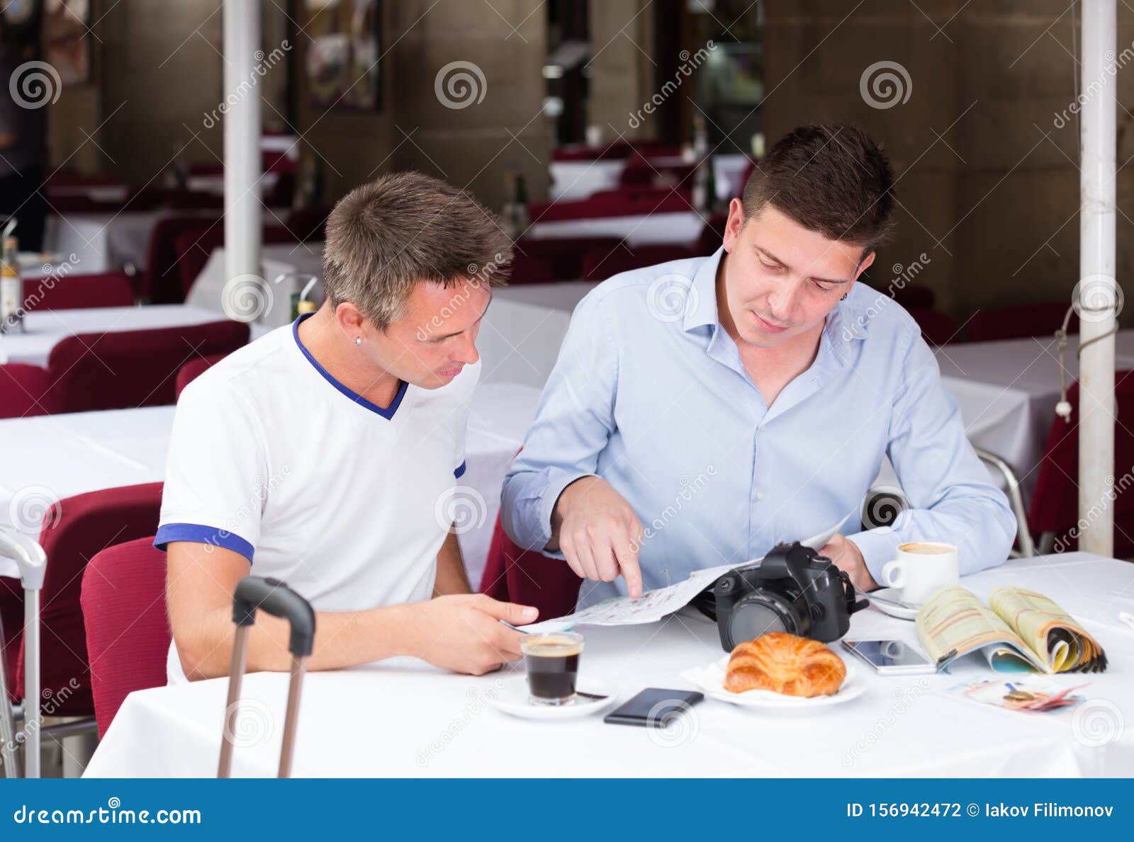Two Men Sitting with Coffee and Looking at Map in Cafe Stock Photo ...