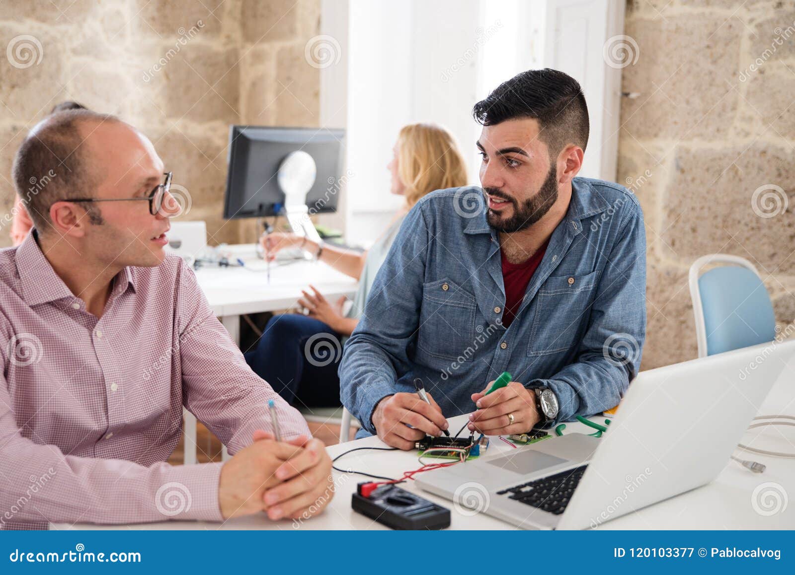 Two Men Sitting at a Desk Talking Over a Computer Stock Image - Image ...
