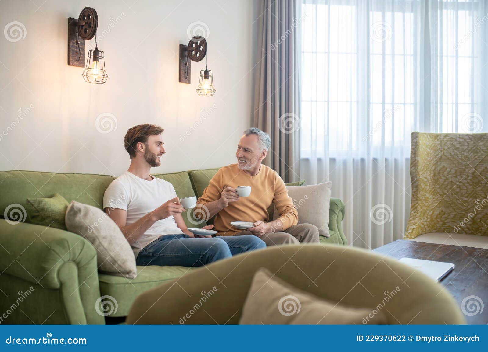 Two Men Sitting on the Sofa and Having Tea Stock Photo - Image of ...