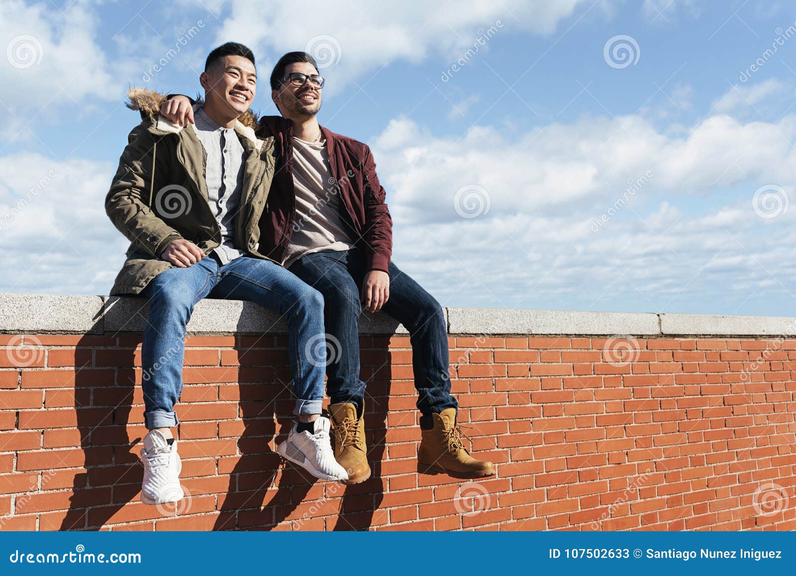 Two Men Sitting On Top Of A Wall Stock Image Image Of Happiness