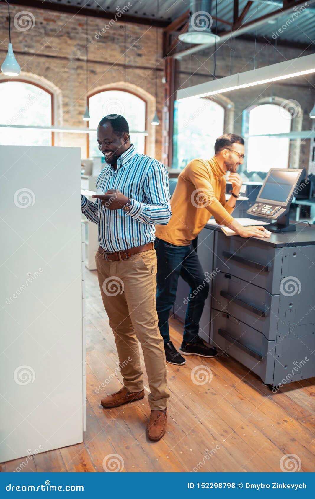 Two Men Smiling while Communicating in Publishing Office Stock Photo ...