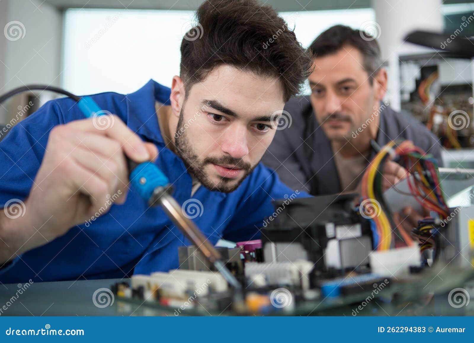 Two men soldering parts stock image. Image of tech, domestic - 262294383