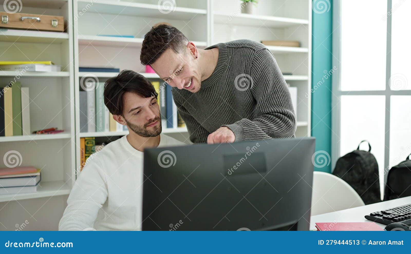 Two Men Students Using Computer Reading Book Studying at Library ...