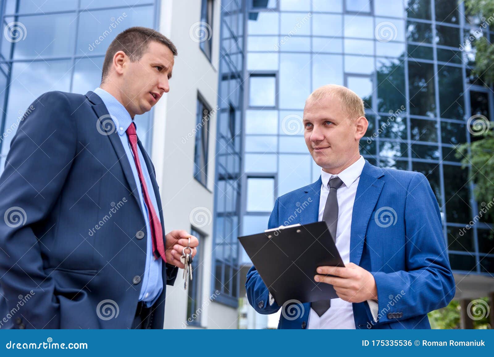 Two Men in Suits with Clipboard and Keys Negotiate Stock Photo - Image ...