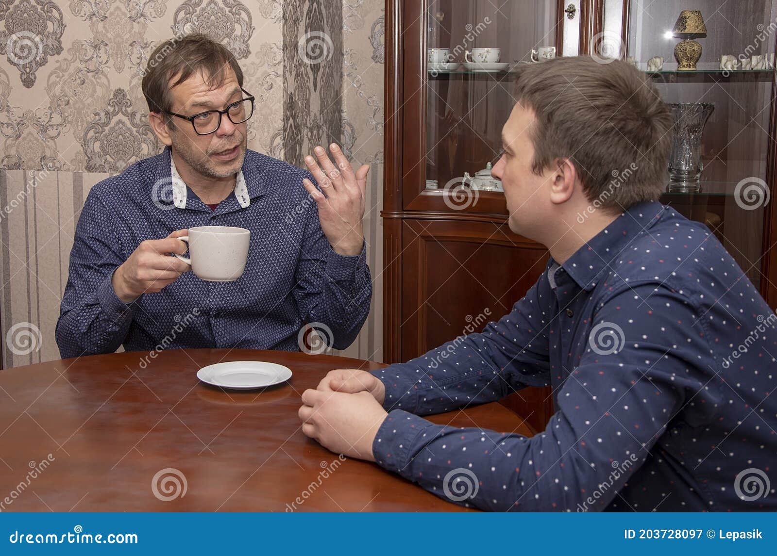 Two Men are Talking at the Desk in the Office Over a Cup of Tea ...