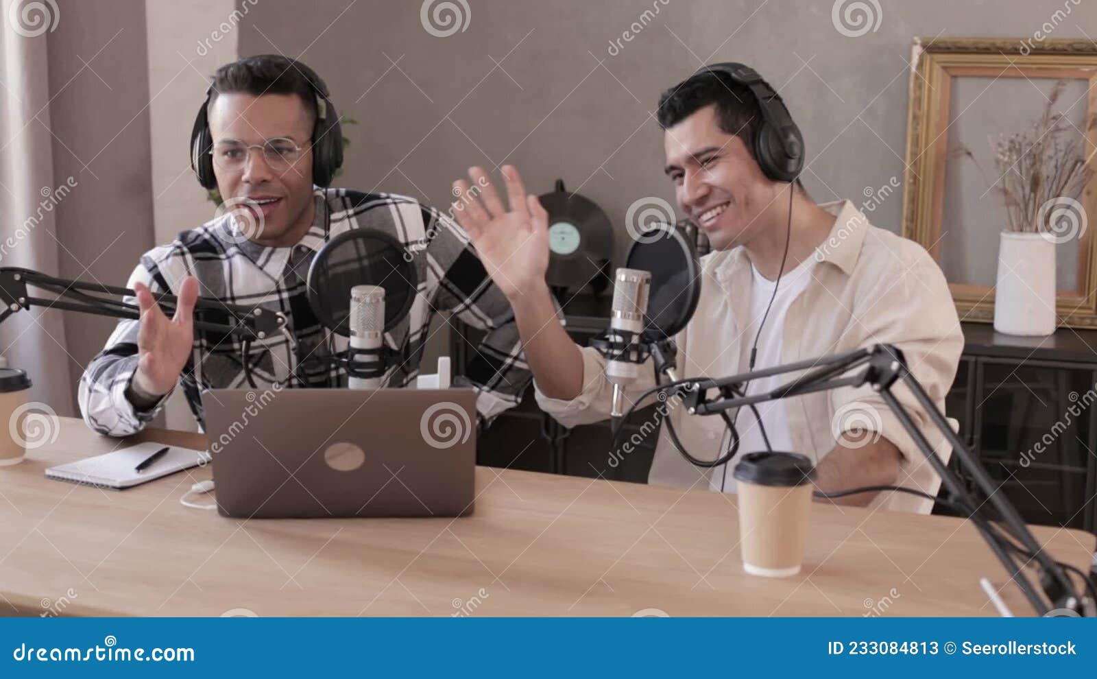 Two Men Talking and Smiling, Sitting at Table in Front of Microphones ...