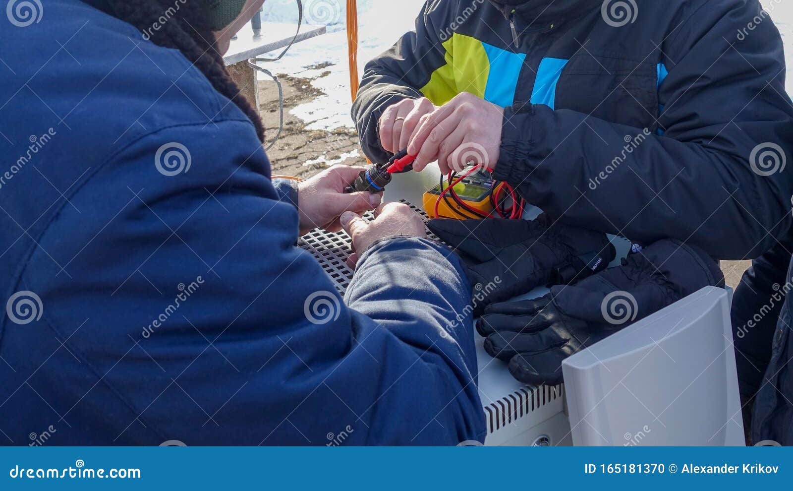 Two Men Use A Digital Multimeter To Check The Interface Cable Connector ...