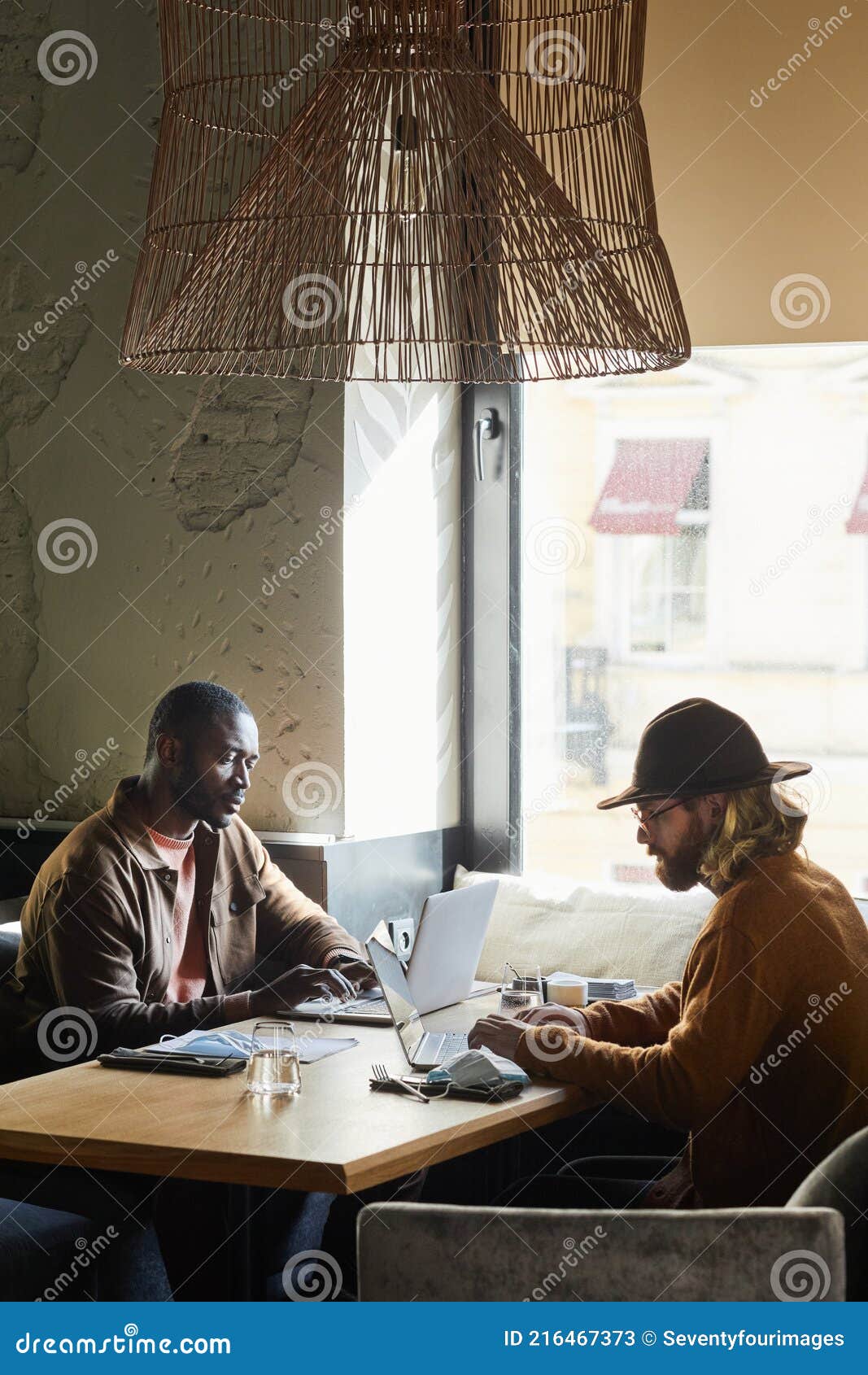 Two Men Using Computers at Cafe Table Stock Image - Image of ...