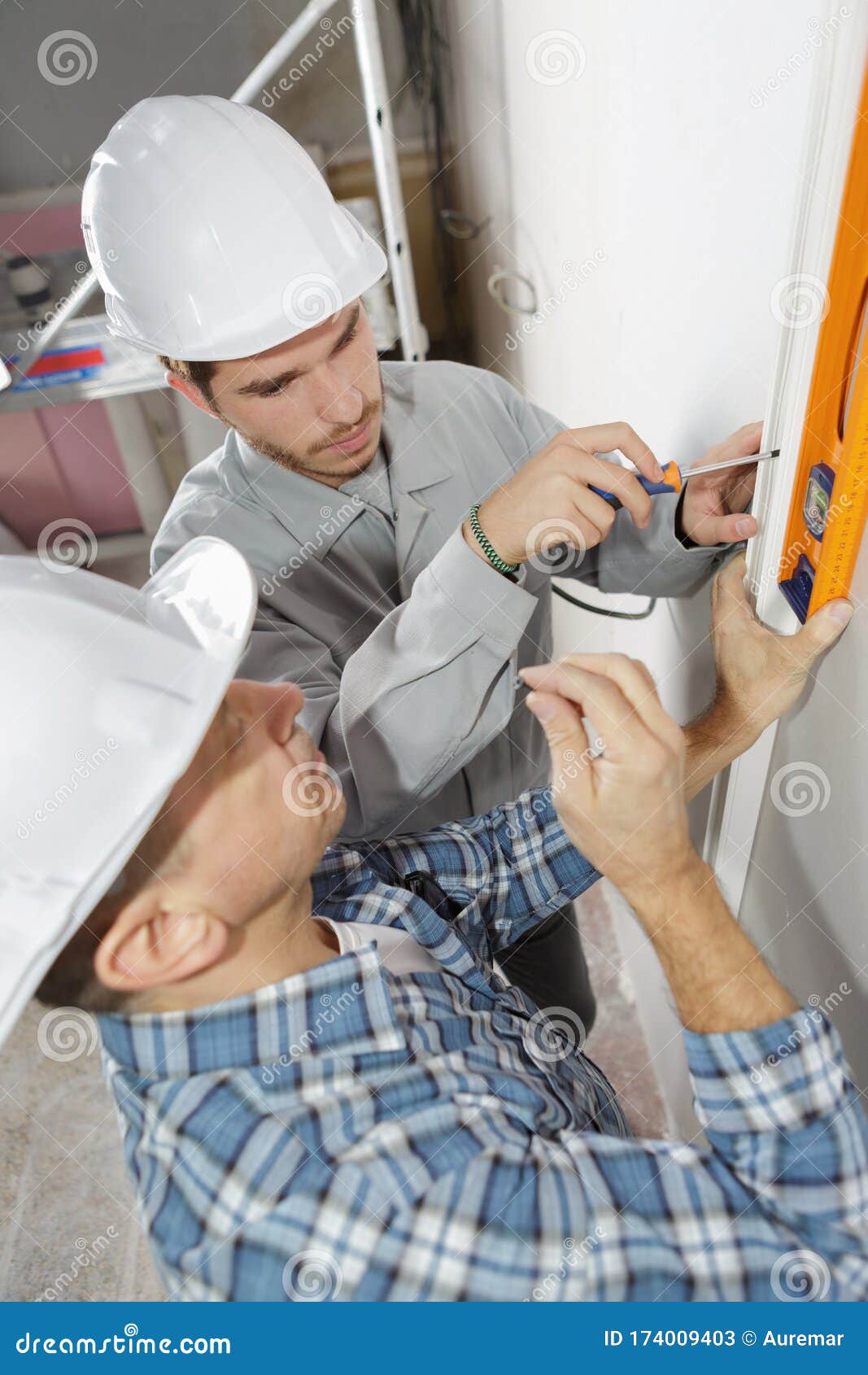 Two Men Using Spirit Level on Wall Stock Image - Image of level, shirt ...