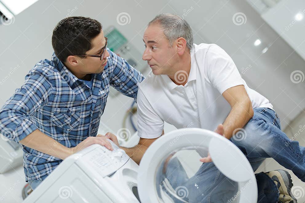 Two men by washing machine stock photo. Image of washing - 124187076