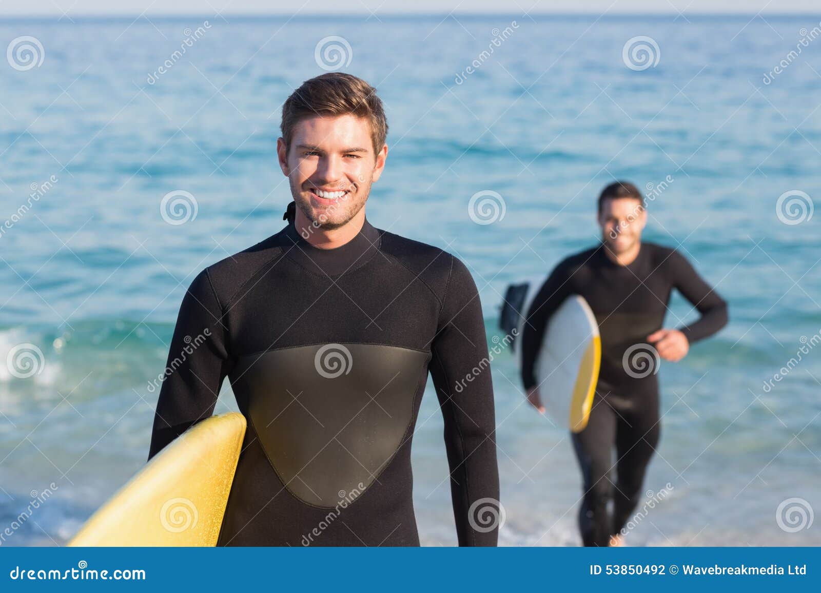 Two Men in Wetsuits with a Surfboard on a Sunny Day Stock Photo - Image ...