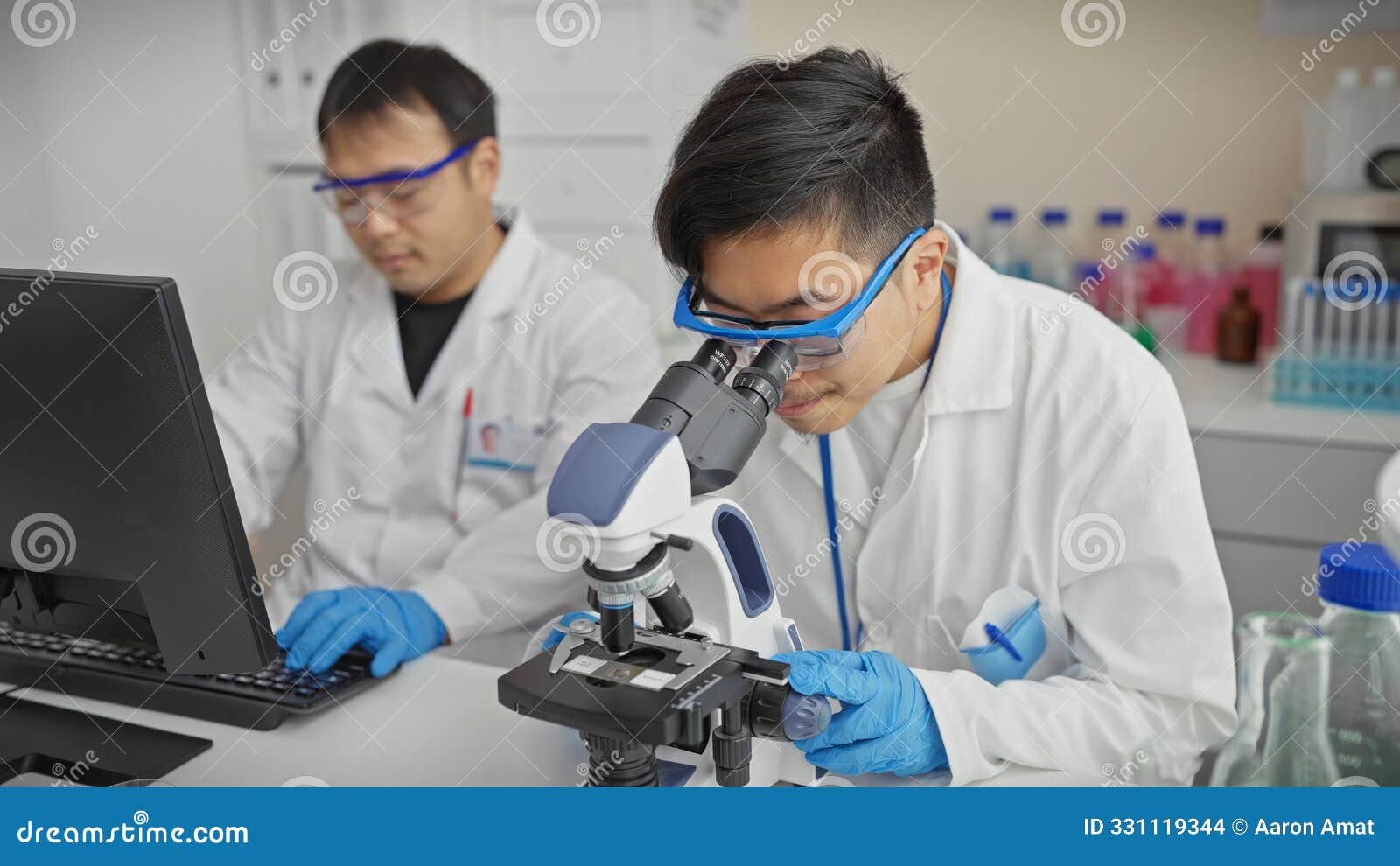 Two Men Working Collaboratively in a Modern Laboratory, One Using a ...