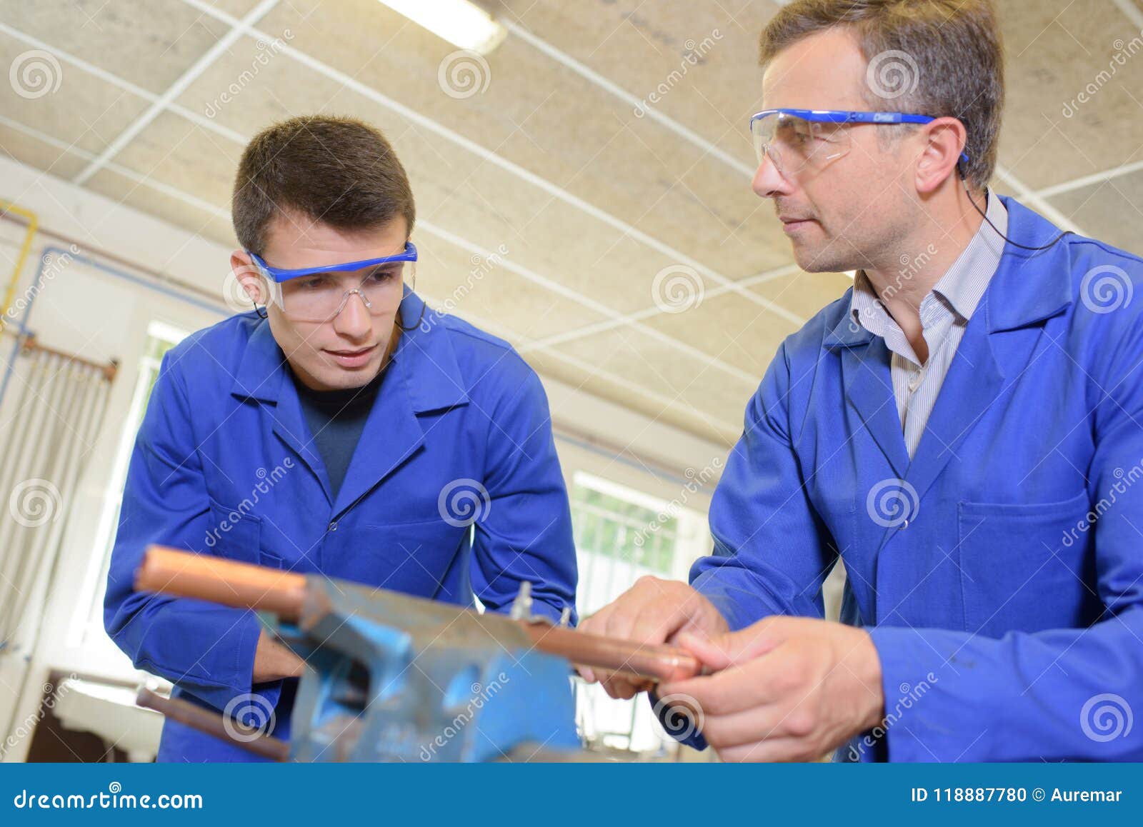 Two Men Working on Copper Pipe Held in Vice Stock Photo - Image of ...