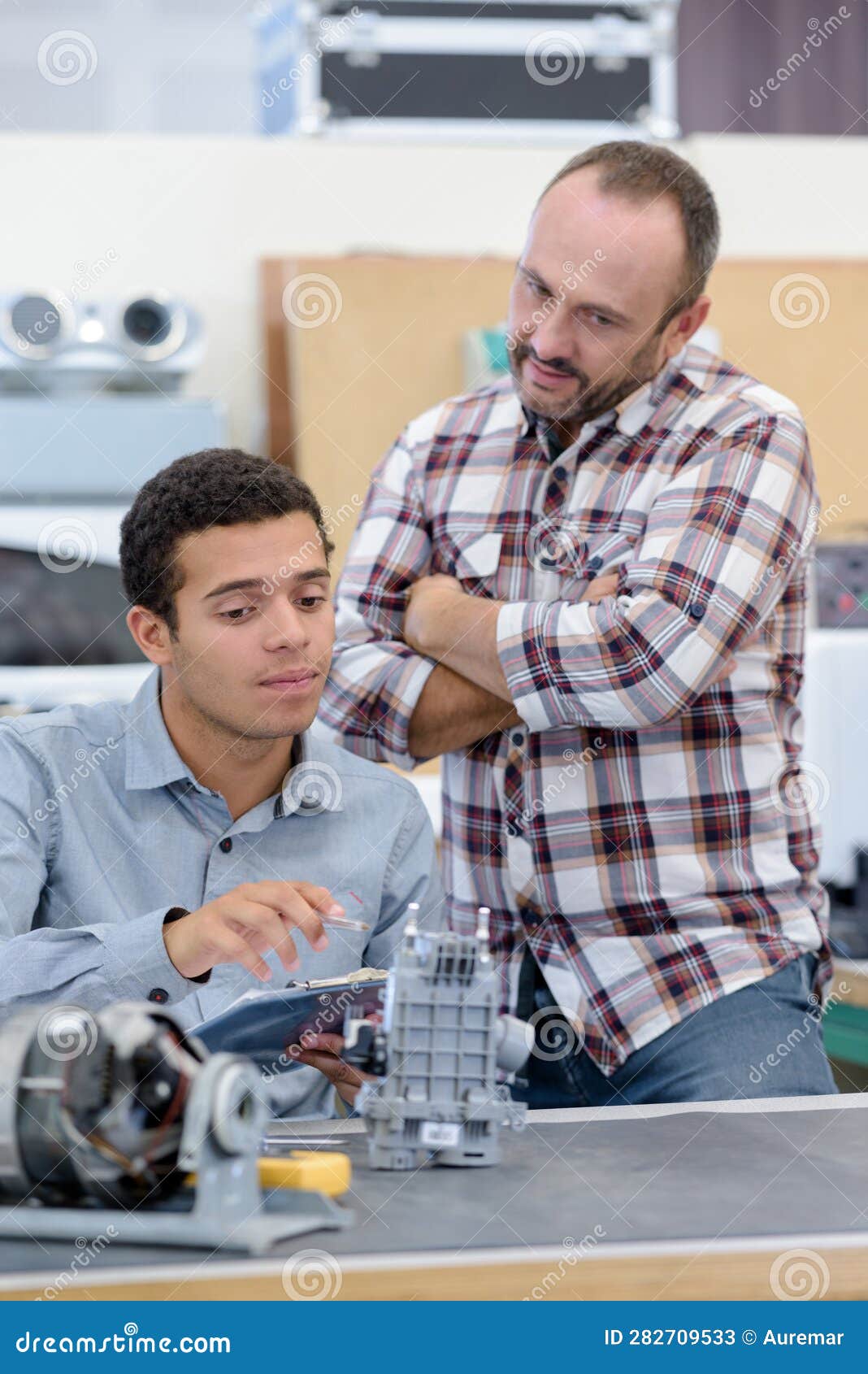 Two men working at factory stock image. Image of three - 282709533