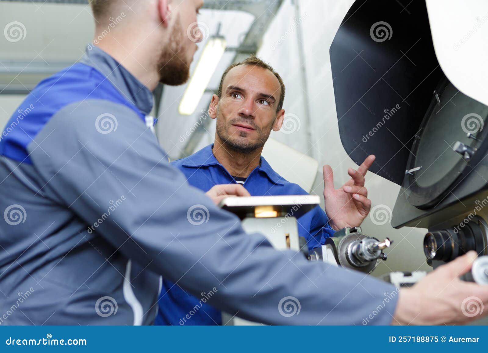 Two men working on machine stock image. Image of operative - 257188875
