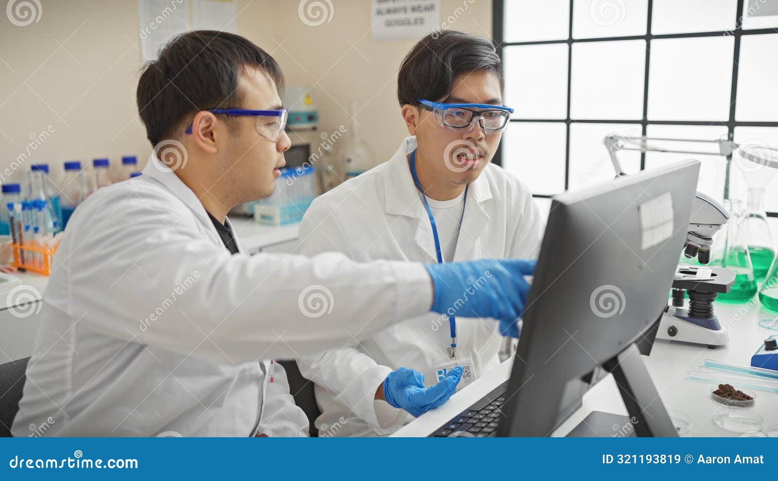 Two Men Working Together in a Laboratory, Analyzing Data on a Computer ...