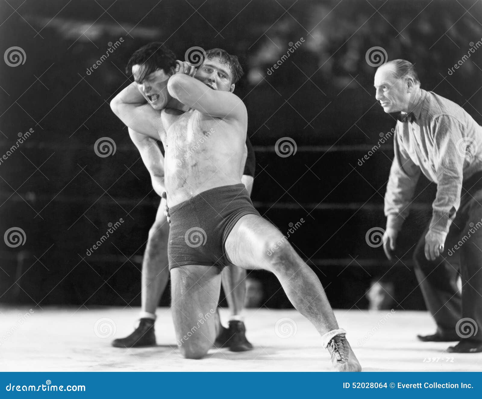 Two Men Wrestling with Referee Making a Call in the Background Stock ...