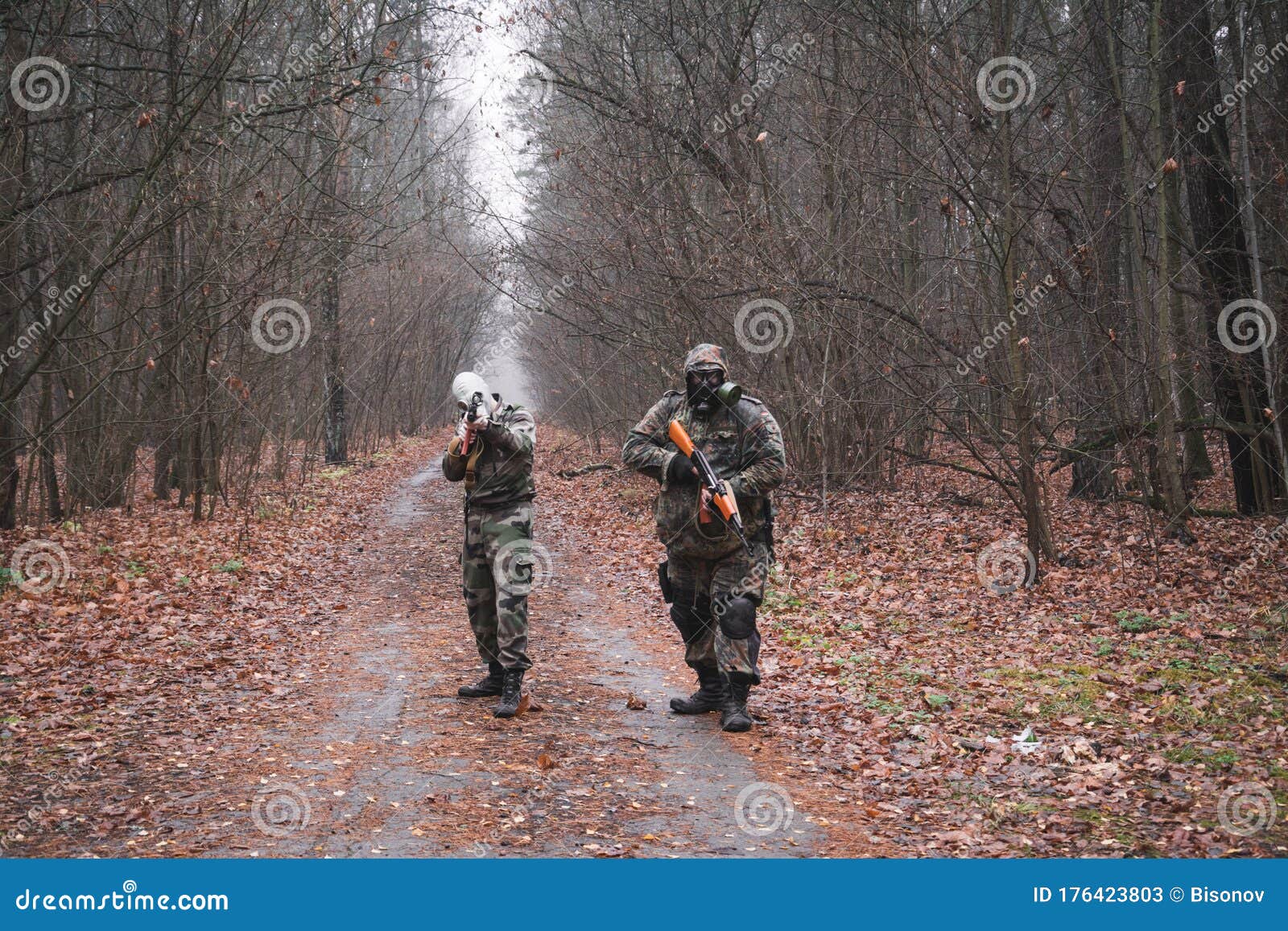 Two Military Men with Weapons in Their Hands Move through the Forest in ...