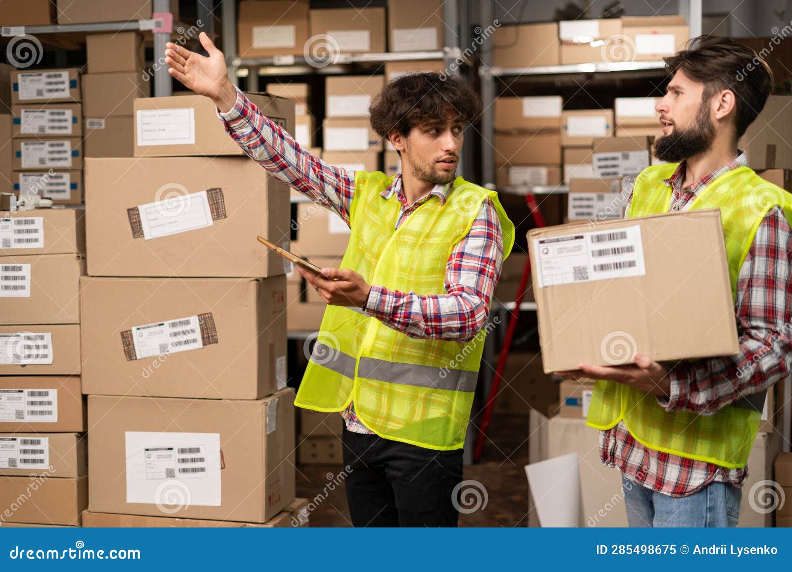 Two Mixed Race Warehouse Workers Preparing a Shipment in a Large ...