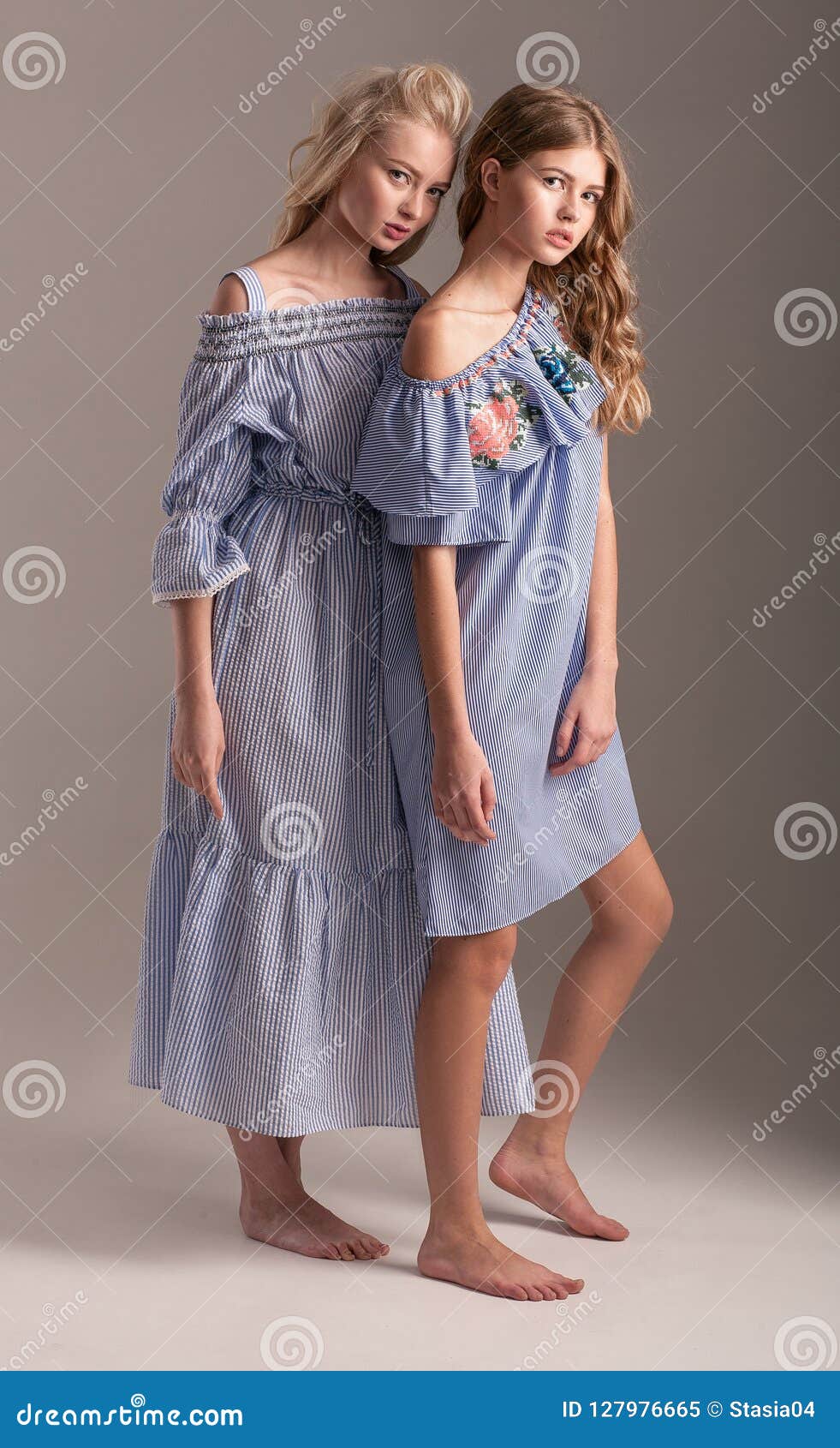 Two Models in Blue Dresses Posing on Gray Background. Stock Image ...