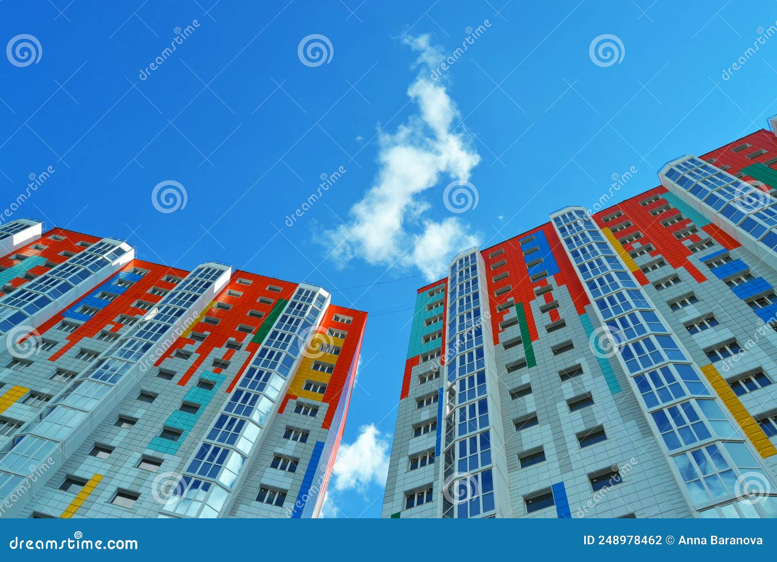 Two Multi-colored Skyscrapers Against a Blue Sky with Clouds Stock ...