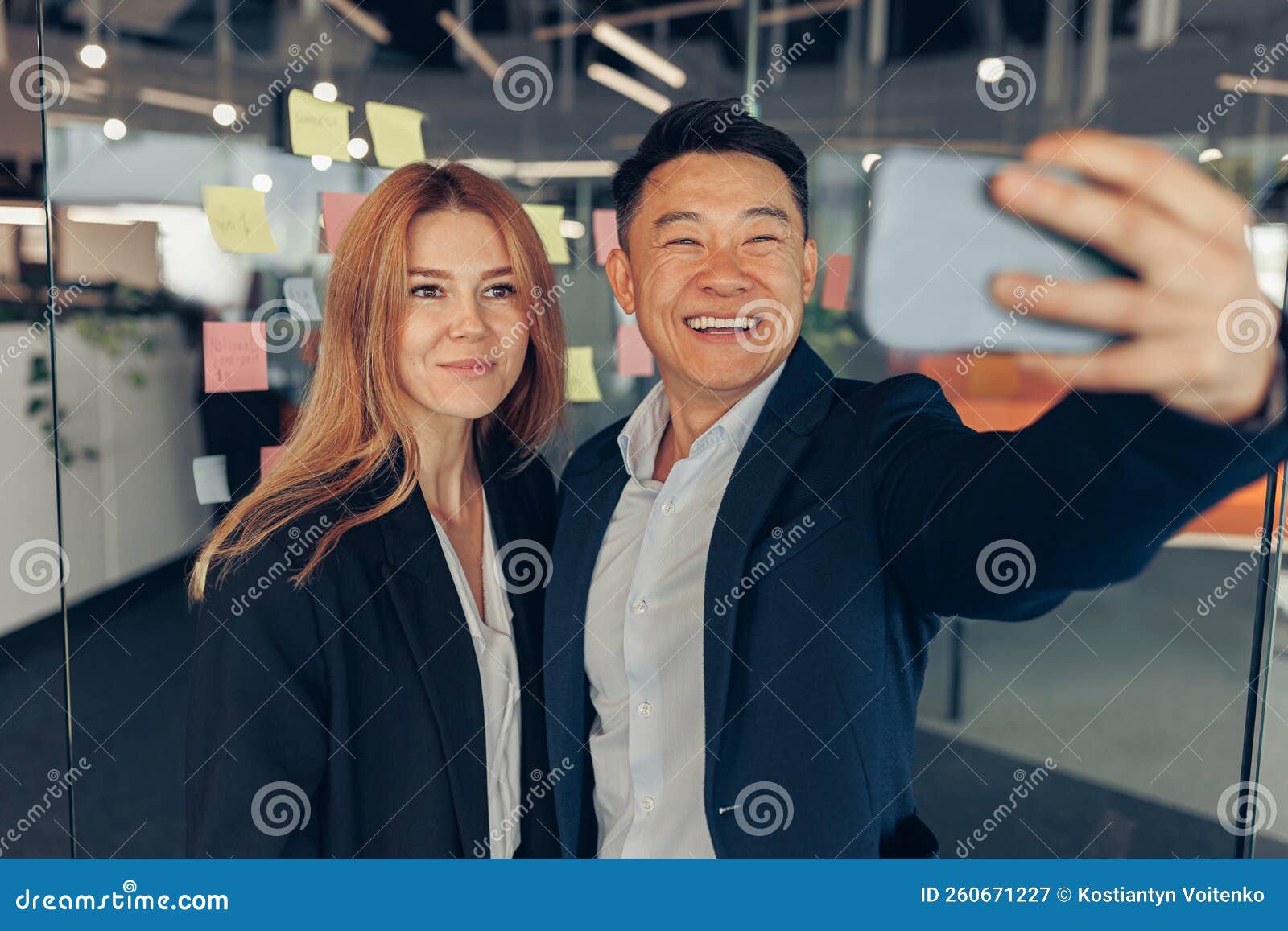 Two Multi Ethnic Business Colleagues Taking Selfie While Standing In