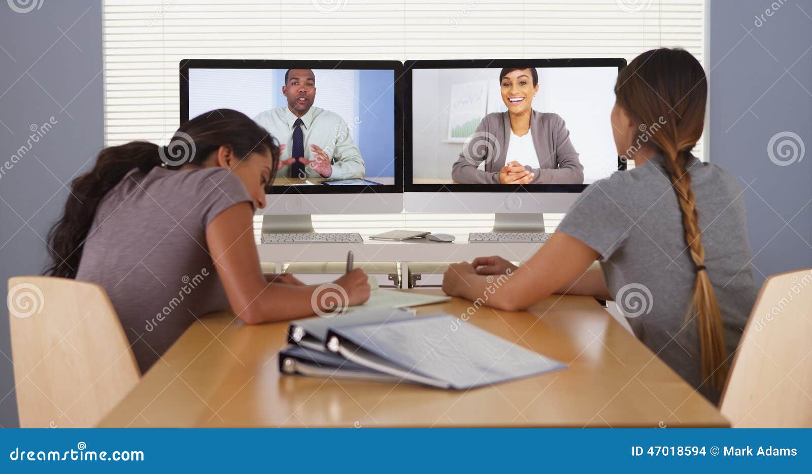 Two Multi-ethnic Businesswomen Talking with Tablet at Desk Stock Photo ...