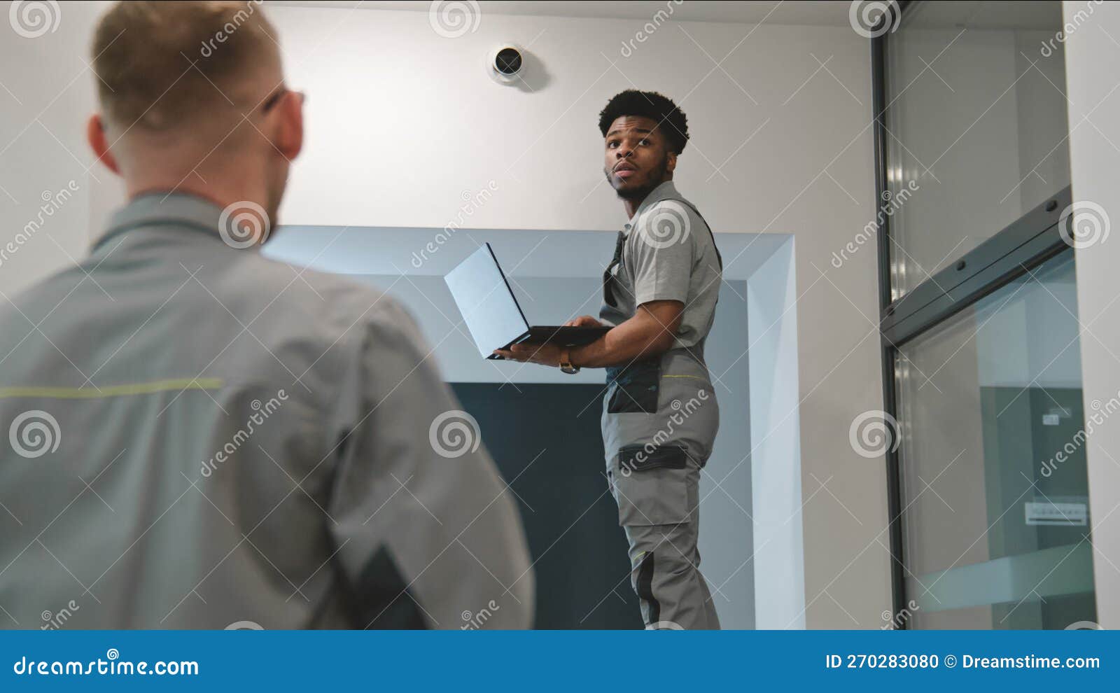 Multi Ethnic Installers Sets Up Security Camera in Office Hallway Using ...