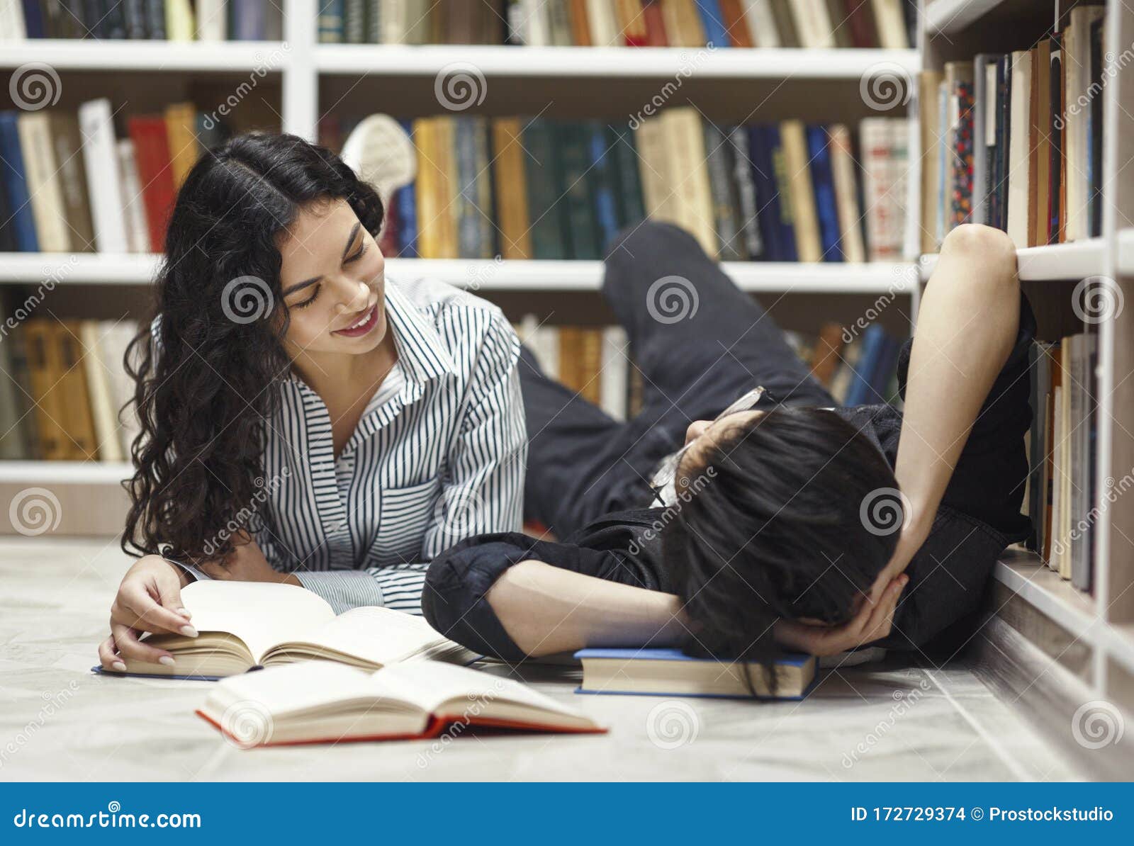 Two Multicultural Students Lying on Floor at Library Stock Photo ...