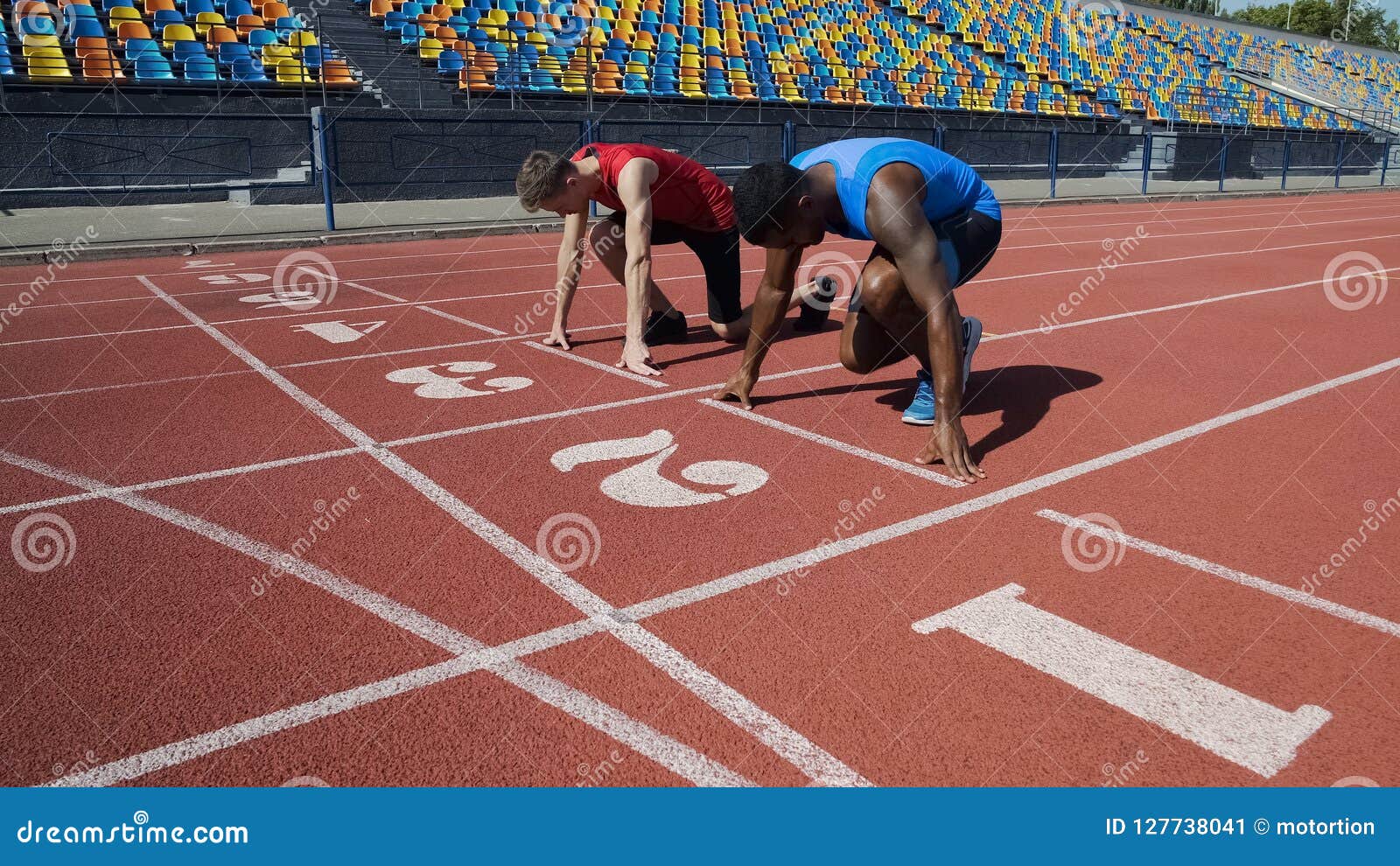 Two Multiracial Athletes in Starting Position, Ready To Run after ...