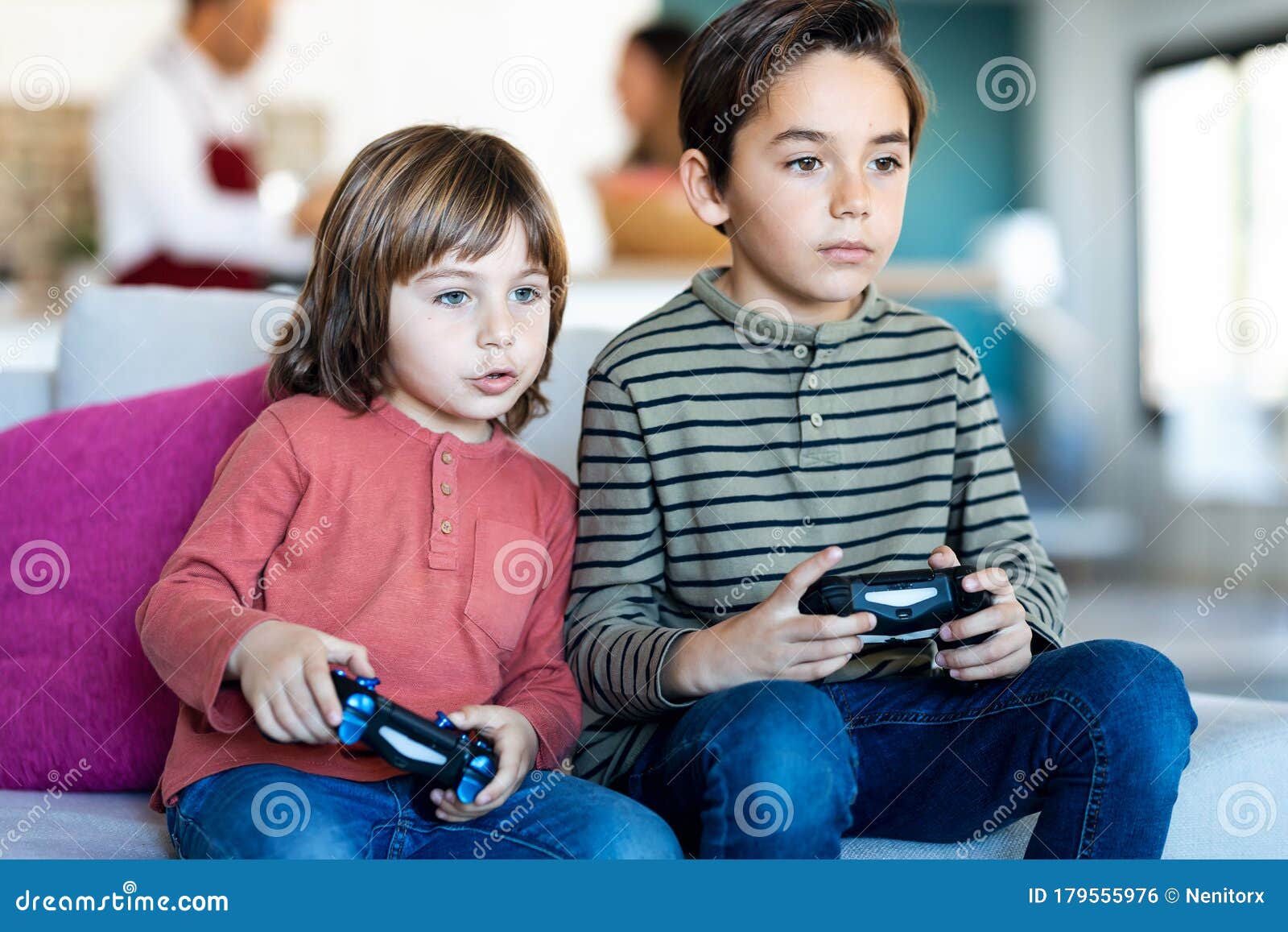 Two Nice Brothers Playing Video Games while Sitting on the Sofa at Home ...