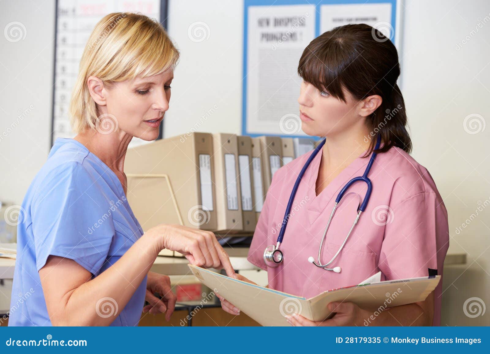 Two Nurses Discussing Patient Notes at Nurses Station Stock Image ...