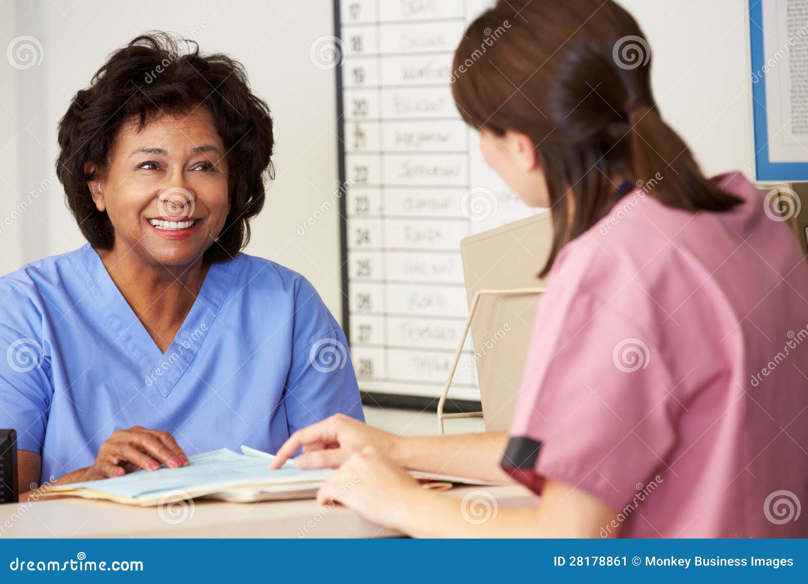 Two Nurses in Discussion at Nurses Station Stock Image - Image of ...