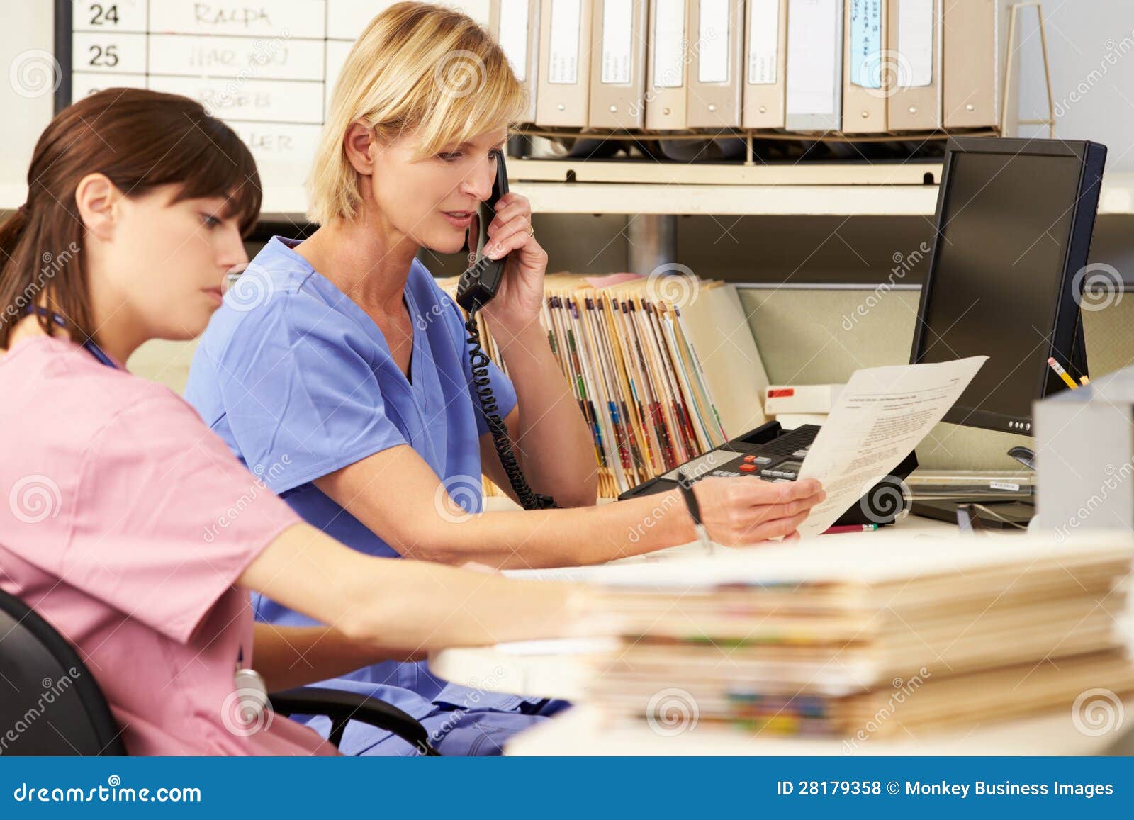 Two Nurses Working at Nurses Station Stock Photo - Image of scrubs ...