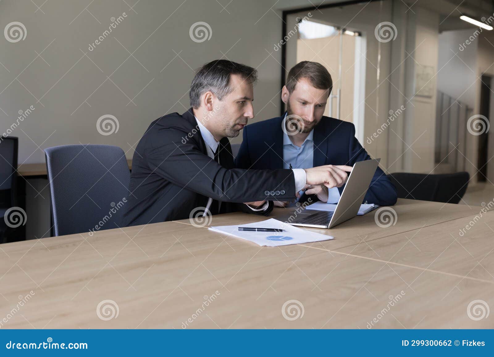 Two Office Employees Using Laptop, Engaged in Teamwork in Office Stock ...